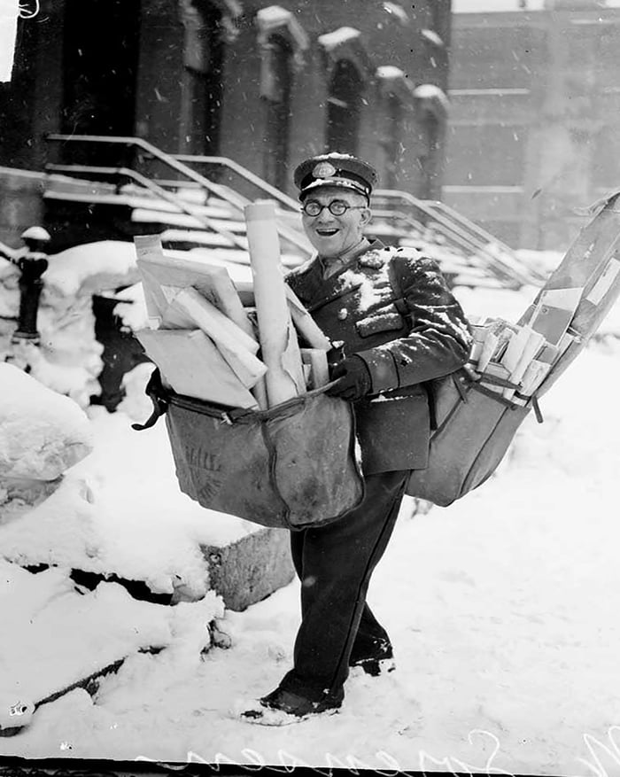 Mailman poses with his heavy load of Christmas mail and parcels ...