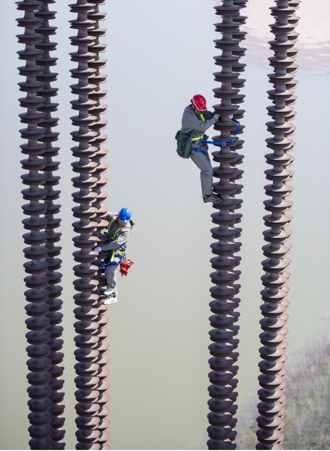 Linemans working on the giantic insulators from a new mega pylon, 385 meters tall. - 9GAG