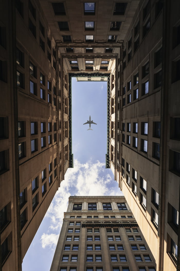 The symmetry of this plane, framed by buildings. - 9GAG
