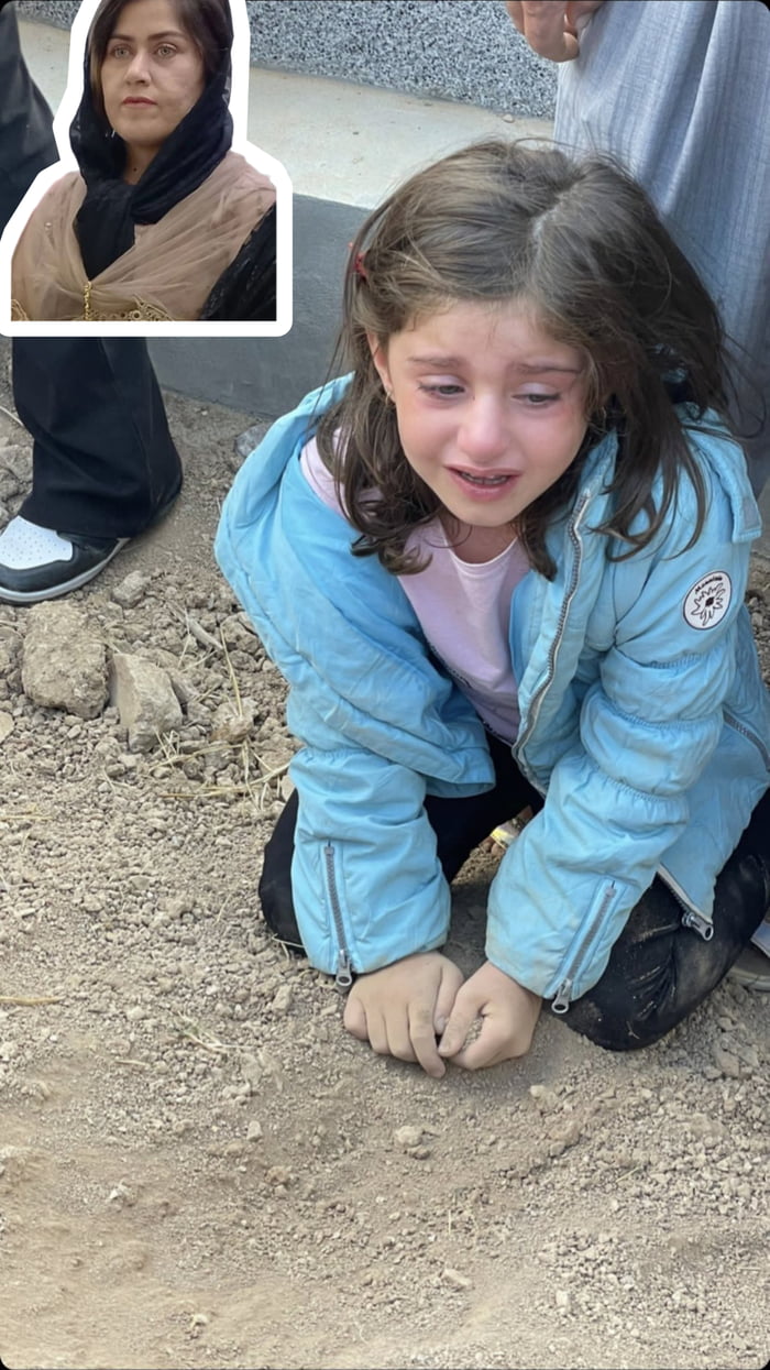 A girl is crying over the grave of her mother, who was shot dead by ...