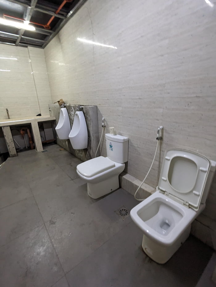 A men's restroom with no partition walls in between toilets - 9GAG