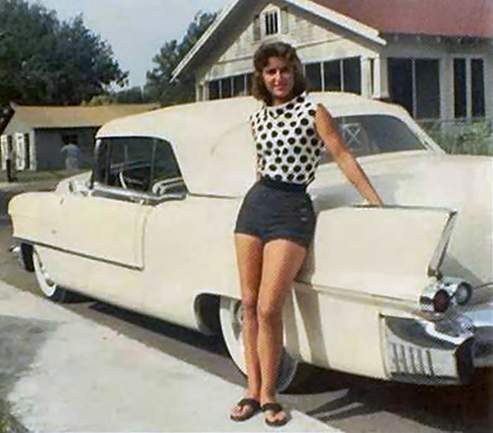 June Juanico posing beside a 1956 Cadillac Convertible in front of her ...