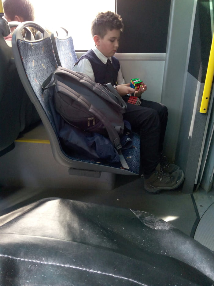 Kid solving 2 Rubik's cubes on the bus.. I like this kid - 9GAG