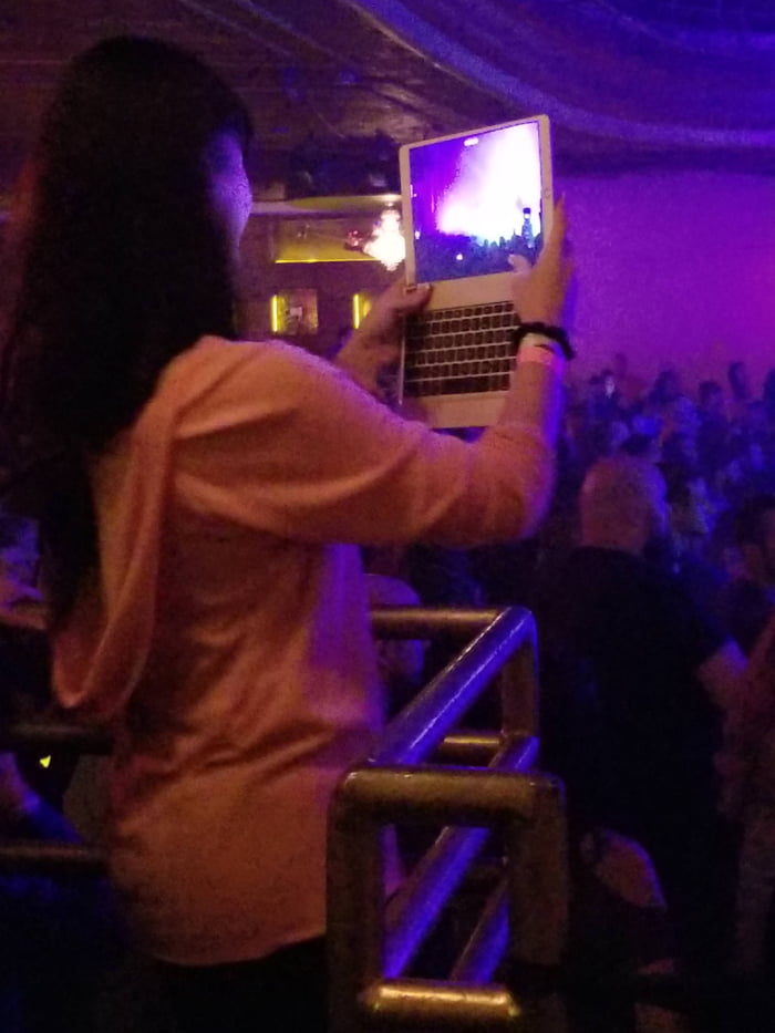 Woman videoing a concert on a laptop - 9GAG