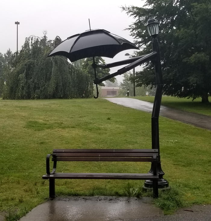 This lamp post holding up an umbrella for a spot on the bench. - 9GAG