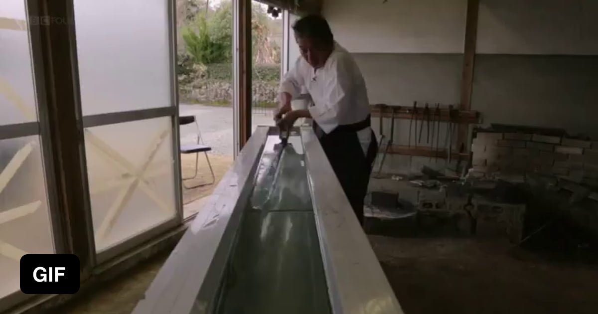 A katana receives it's signature upward curve as it's being cooled down in water from 800 ...