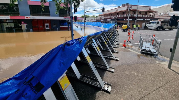 Temporary levee holding back floodwaters from entering the town ...