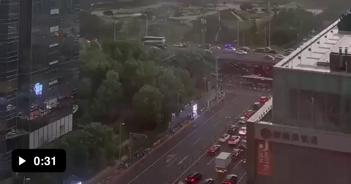 Glass maintenance workers caught in strong winds dangle from the CCTV ...