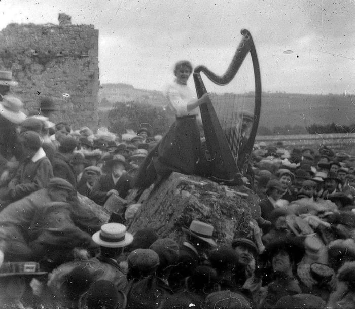 A young lady playing a large harp to the crowd in 1910 Ireland - 9GAG