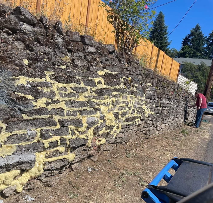 Neighbors think they can reinforce their stone wall with…….spray foam ...