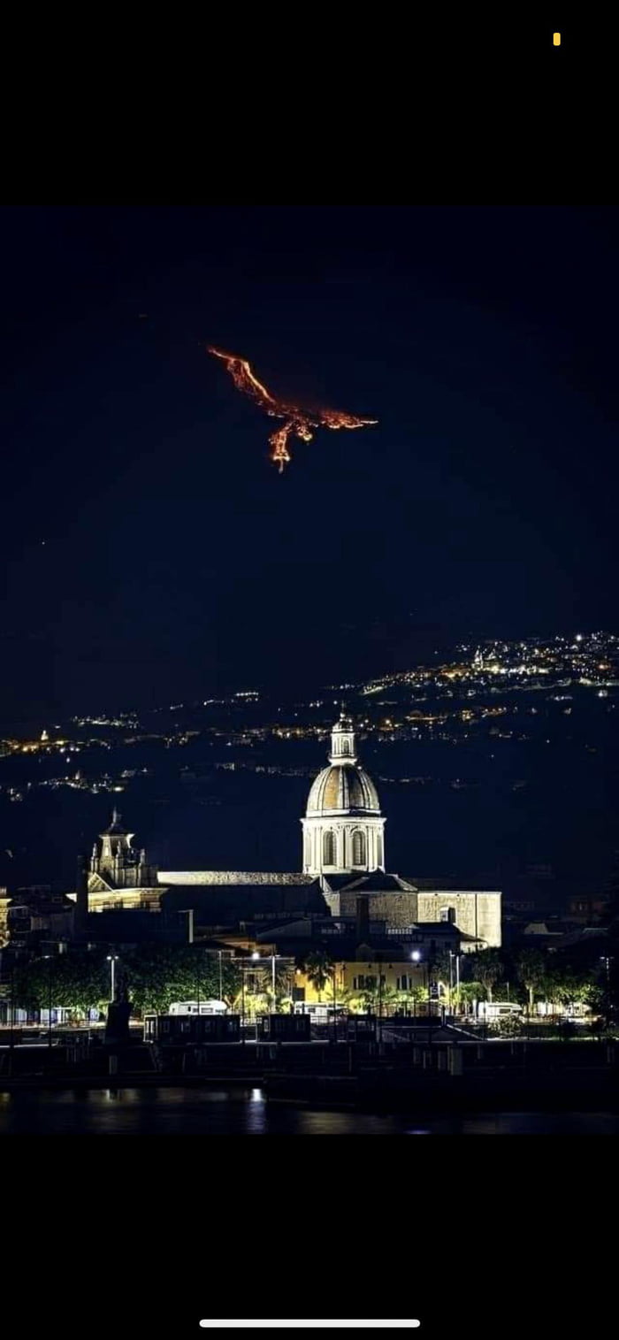 Mt. Etna erupting in Sicily looks like a Phoenix flying above the city ...