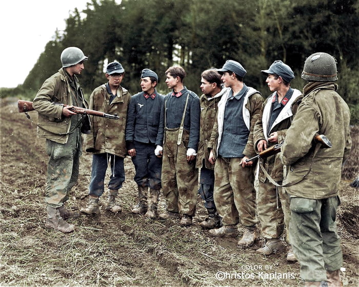 Two GIs of the 4th Infantry Division guard a group of teenage German ...