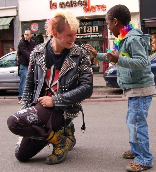 A punk guy stopping to let a kid touch the spikes of his jacket during ...