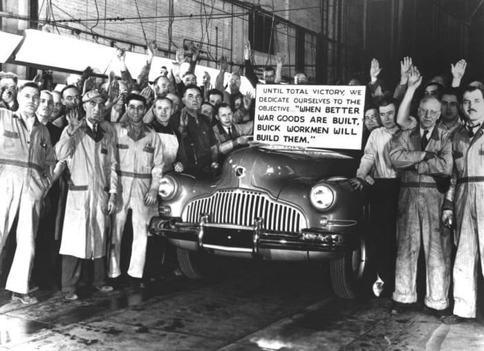 Factory workers surrounding the last Buick to be built until the end of ...