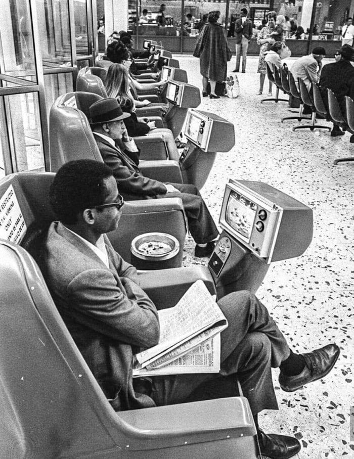 Passengers watching coin-operated TV’s at “Tel-A-Chair” stations in the ...