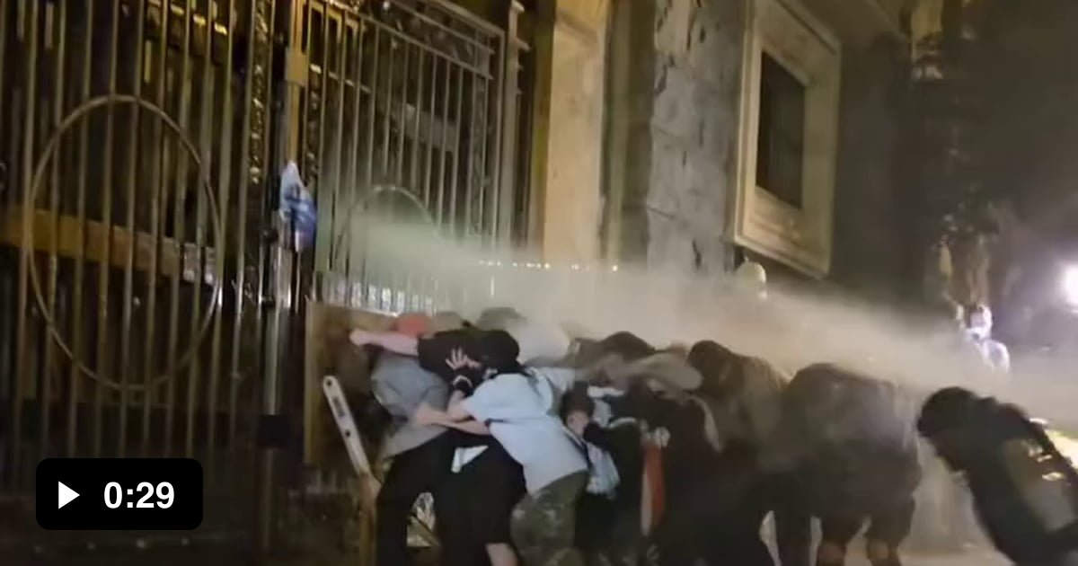 A scrum formed by protesters defending each other against water cannon ...