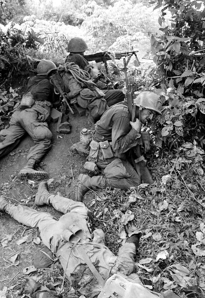 A US Marine machine gunner fires at North Vietnamese positions near ...