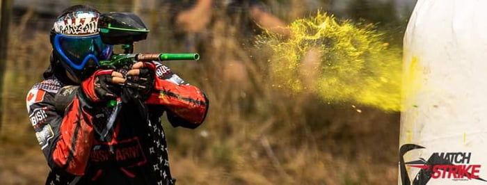 A Paintball player shooting another paintball out of the air. Captured ...