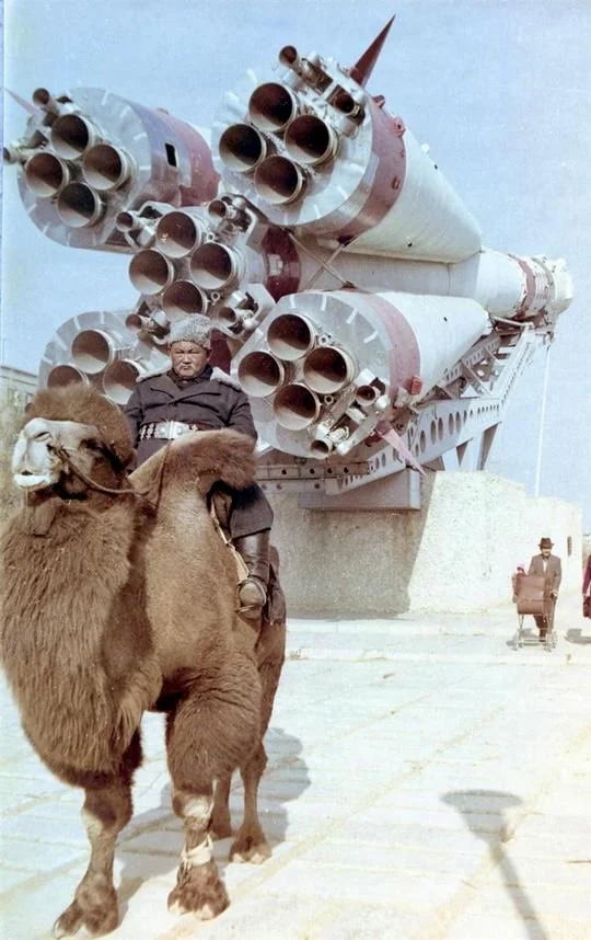 Man on a camel posing for a photo in-front of Soyuz rocket,1980s ...