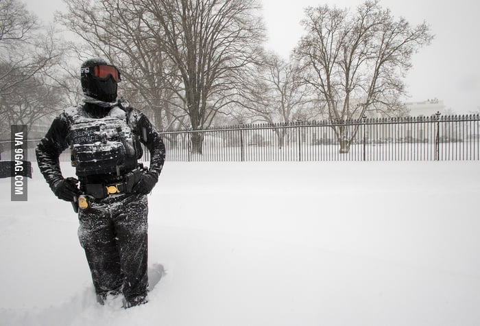 A U.S. Secret Service police officer stands guard knee-deep snow ...