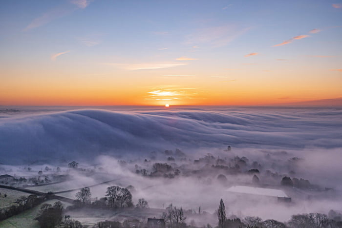 The morning fog blankets the land as the sun rises, Somerset, UK - 9GAG