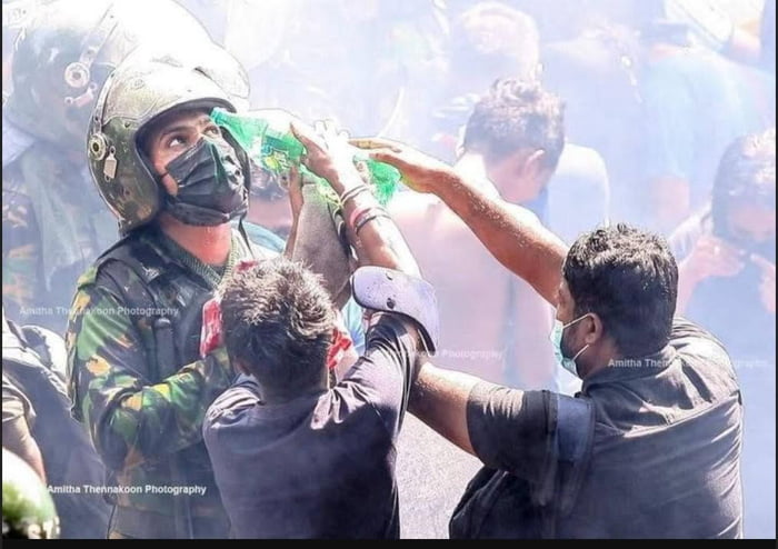 Sri Lankan protestors helping an army soldier to overcome teargas pain ...