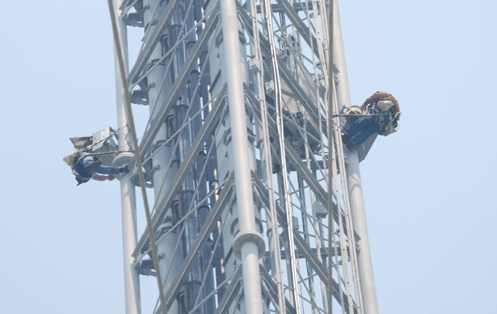 Tower climbers working on a 2000ft tall guyed tower. - 9GAG