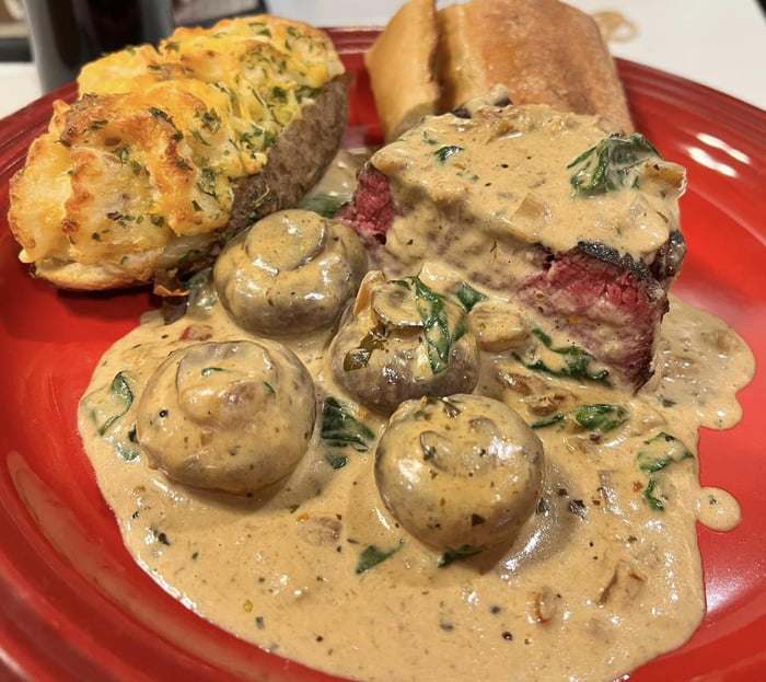 Medium rare filet mignon with creamy garlic butter Tuscan mushrooms, baked potatoes, and garlic ...
