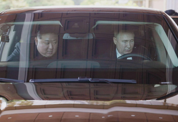 Vladimir Putin driving an Aurus car in Pyongyang with Kim Jong Un as ...