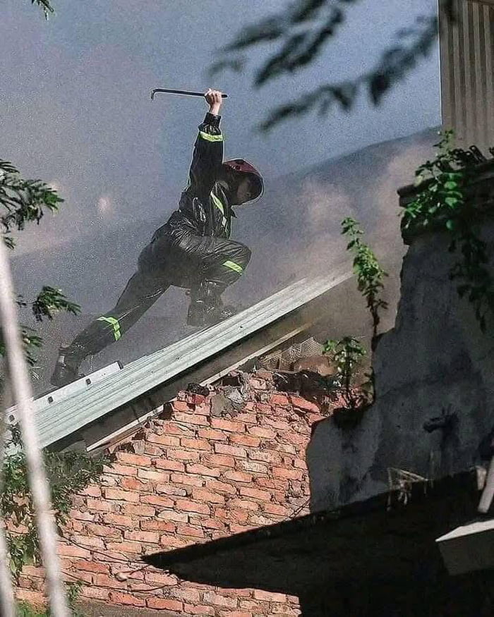 A firefighter in Vietnam is breaking through the roof to rescue trapped ...