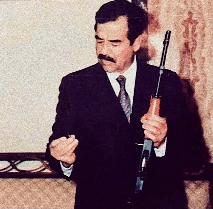 Iraqi dictator Saddam Hussein examining the round from a rifle, 1980's ...