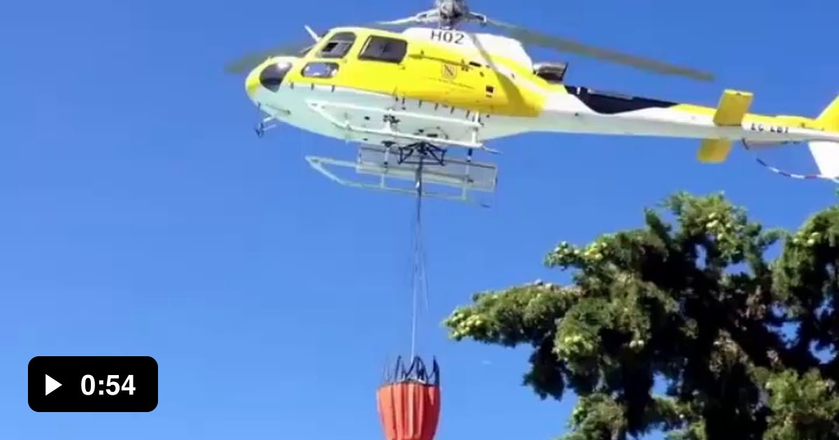 Forest fire helicopter uses a swimming pool to load water into a ...