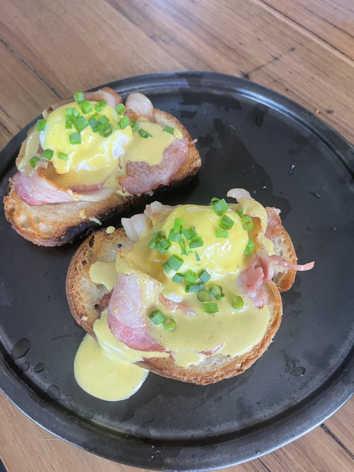 Eggs Benedict with homemade hollandaise, bacon, spring onion on crusty ...