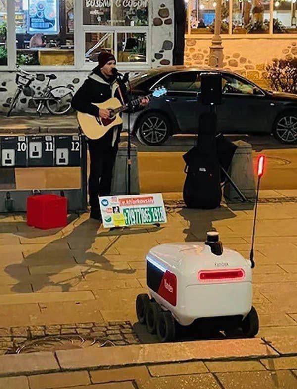 "Now play Battery". Busker playing to a delivery robot. - 9GAG