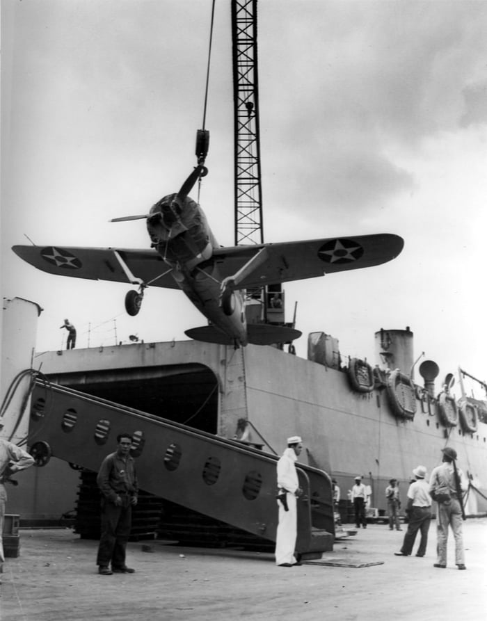 A crane lifts an F2A-3 of VMF-211 aboard USS Kitty Hawk (APV-1) for ...