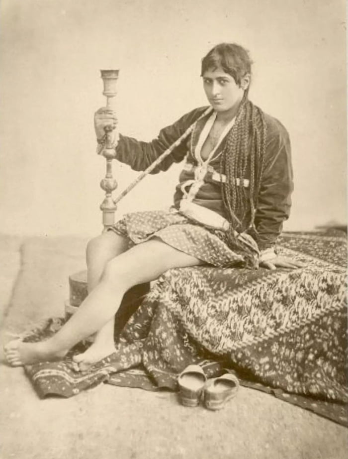 Persian woman holding a Kalgan waterpipe used for smoking, circa 1890 ...