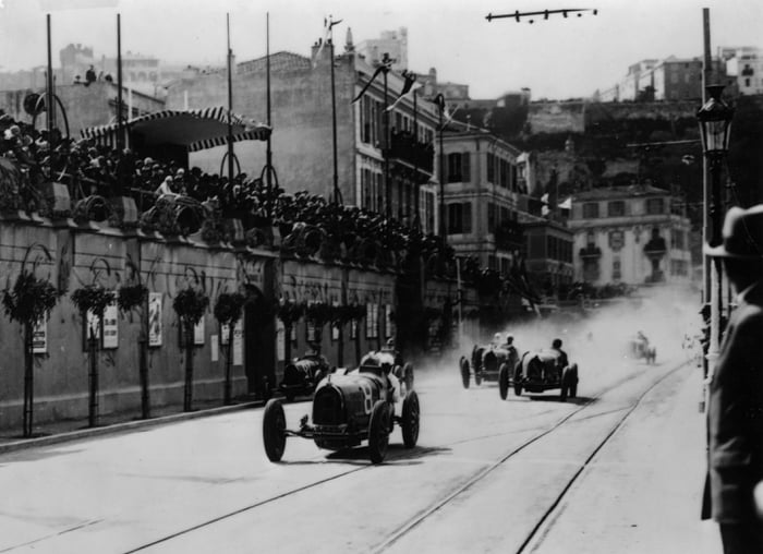 Start of the inaugural Monaco Grand Prix. Crowds watch as the cars ...