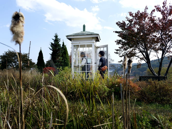 There is a phone booth called "the Wind Phone" on a hill overlooking ...