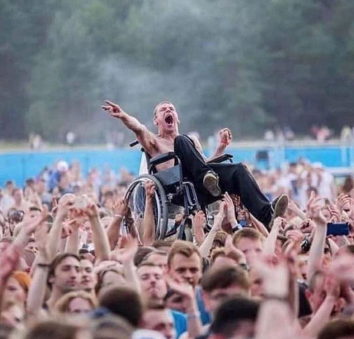 Man in a wheel chair gets lifted up in a concert - 9GAG