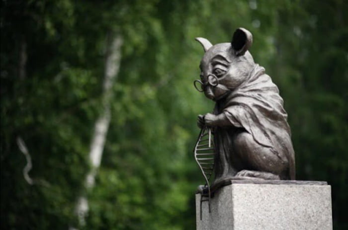 A lab mouse who is knitting a double helix of DNA. This statue is ...