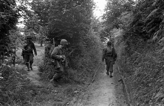 US troops negotiating the narrow sunken lanes of the bocage country in ...