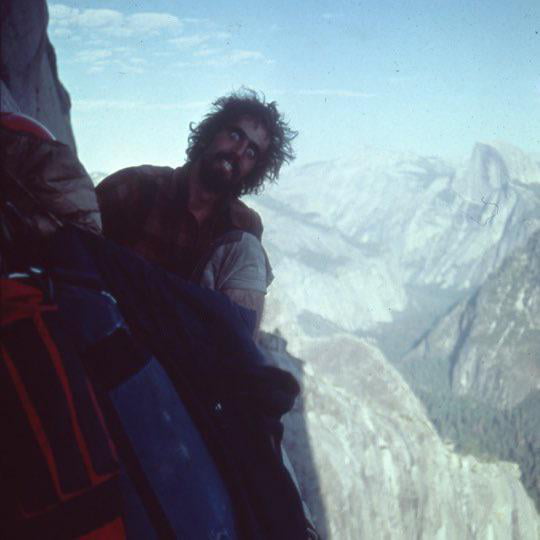 Climber Bill Denz smiling at the camera after waking up on a ledge ...