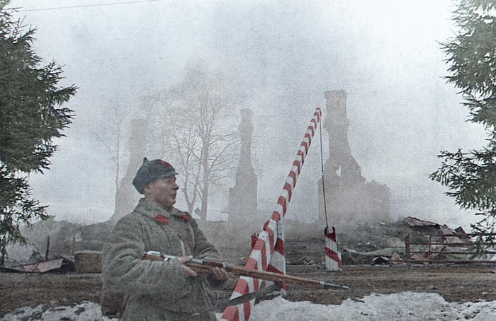 A Soviet soldier standing guard by the recently captured Finnish border ...