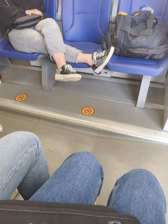 A lady occupying three seats with her body, feet and bag in an ...