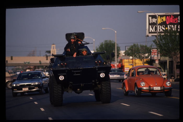 SWAT officers ride an armored vehicle down the street during the 1992 ...