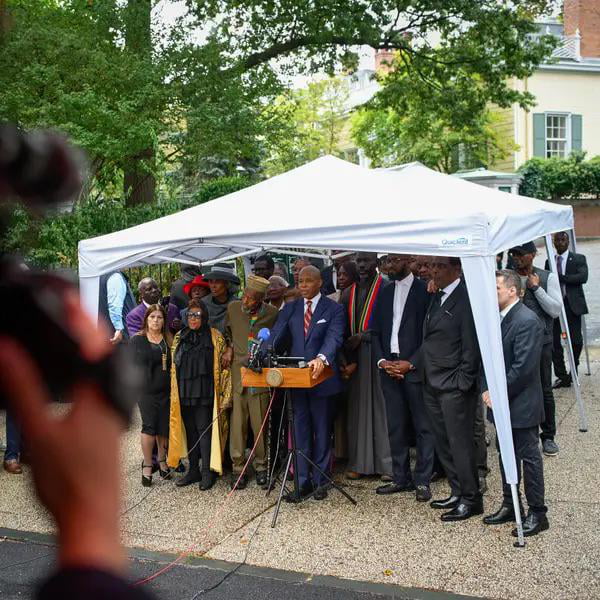 Eric Adams with his entourage deflecting a light drizzle and ...
