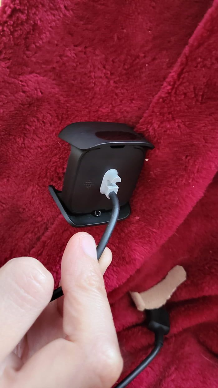 The Fitbit Versa 2 charging cradle. The cable doesn't allow it to sit flat. - 9GAG